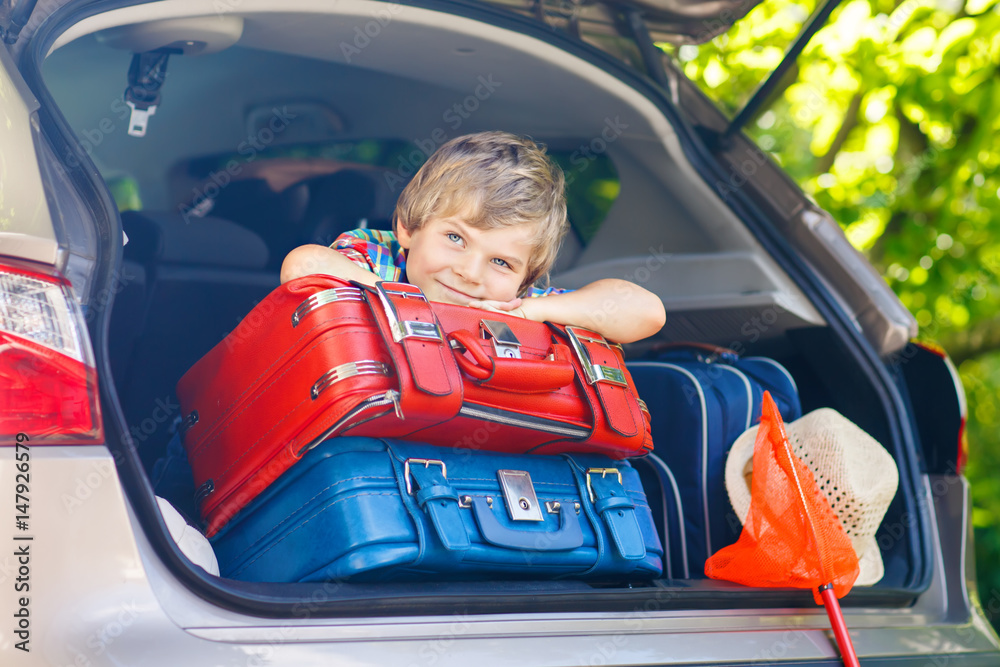 Little kid boy sitting in car trunk just before leaving for vaca Stock ...