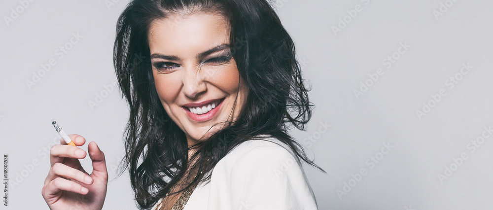 Beautiful woman portrait laughing and winking while smoking cigarette ...