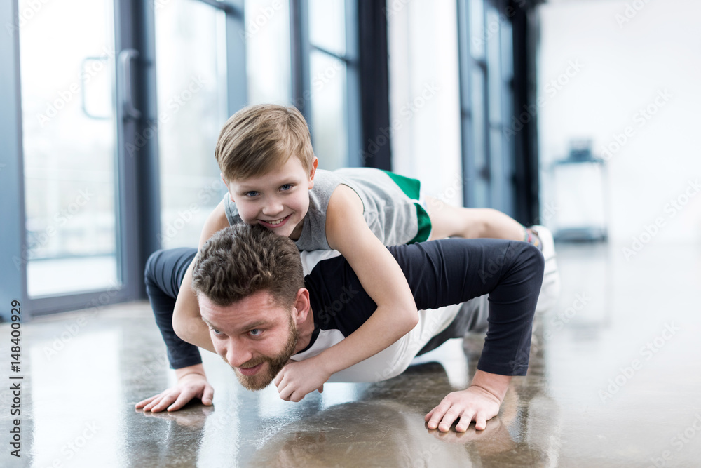 Man doing push ups with boy on his back Stock Photo | Adobe Stock