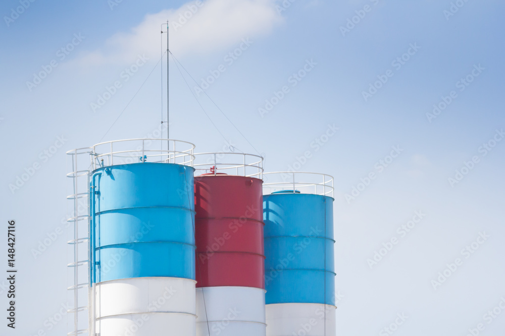blue and red steel silo against blue sky, metal silos for concrete mix ...