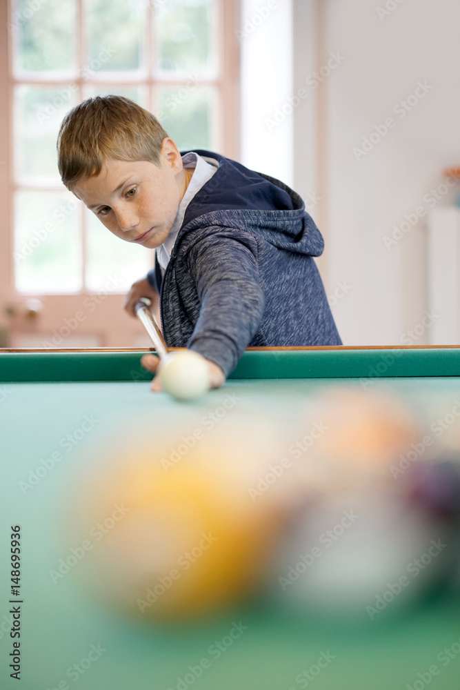 10-year-old kid learning how to play pool foto de Stock | Adobe Stock