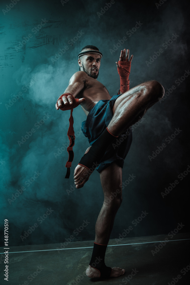 Low angle view of determined Muay Thai fighter training Thai boxing ...