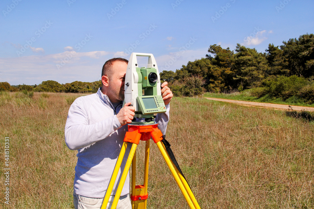 Man using of total station. Guy surveyor at work. Survey Instrument ...