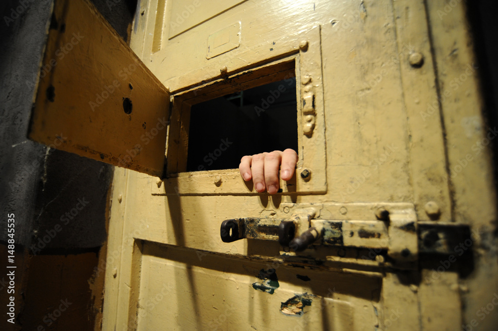 Interior of a bad condition prison cell seen through the door window ...