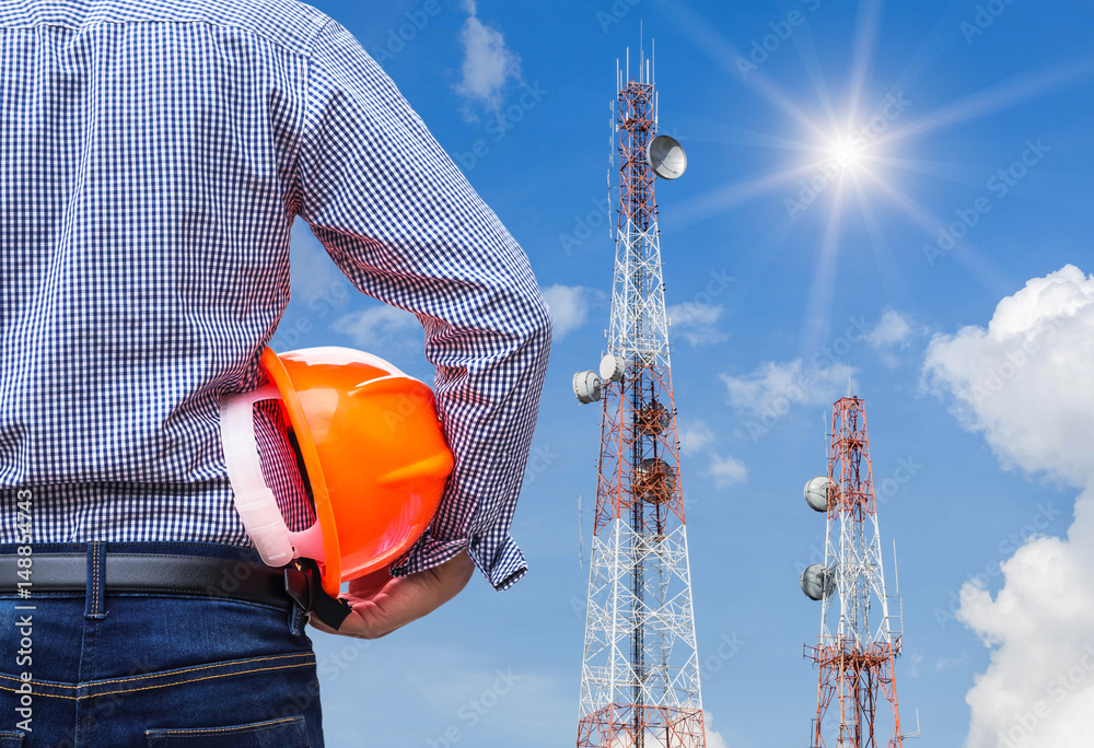 engineer holding safety helmet with telecommunication tower pillars ...