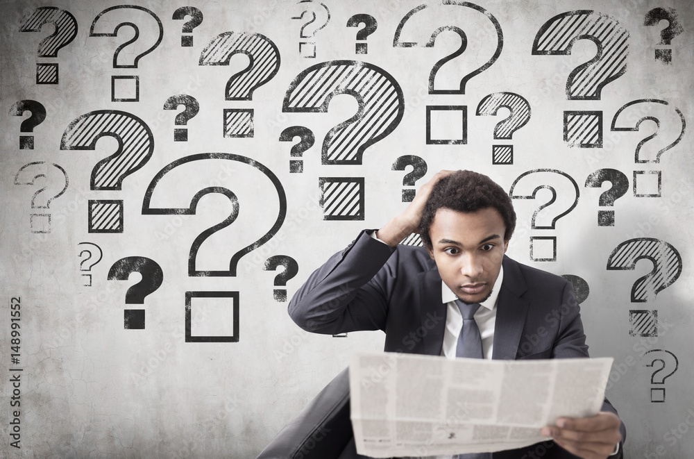 African man with newspaper and question marks Stock Photo | Adobe Stock