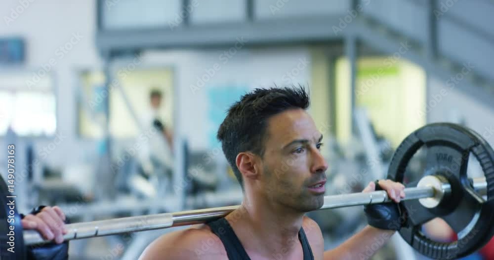 Guy bodybuilder in the gym, works with the barbell, squat, improving ...