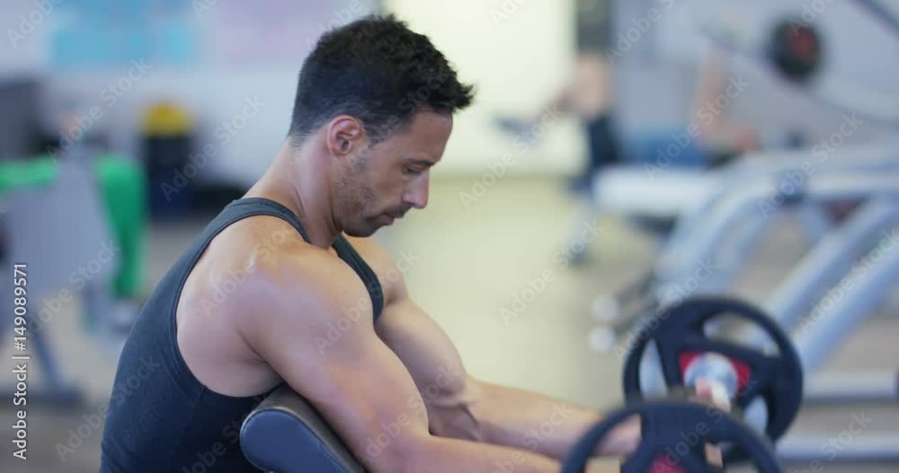 Guy bodybuilder in the gym, works with a barbell, bench press ...