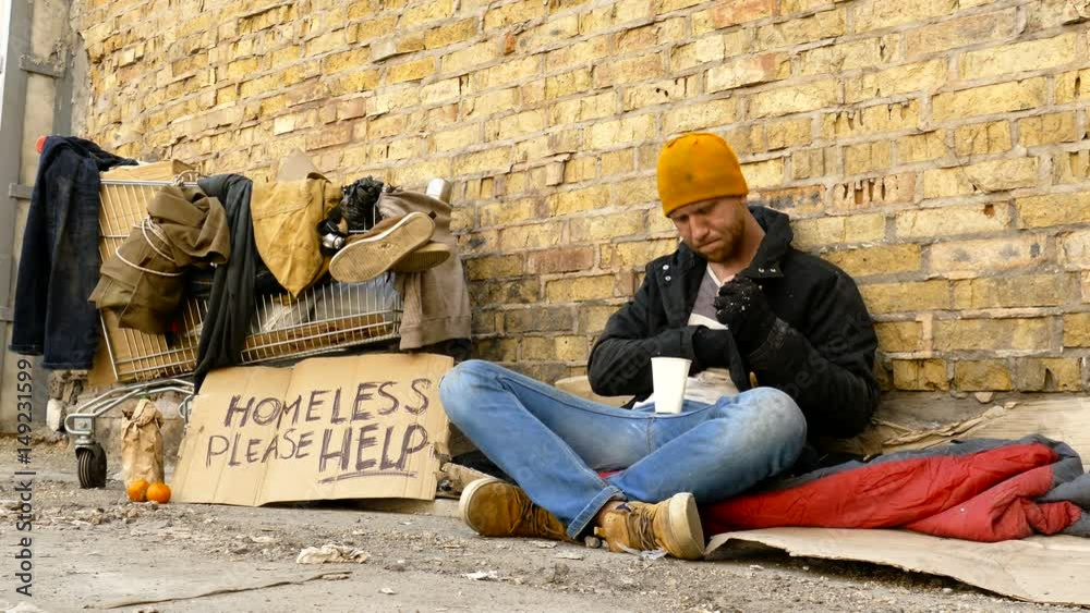 Homeless man counting how much money he got, holding paper cup in the ...