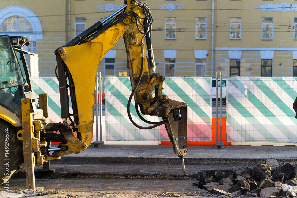 An excavator-mounted hydraulic jackhammer being used to break up ...