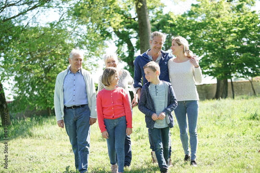 Happy intergenerational family walking in garden Photos | Adobe Stock