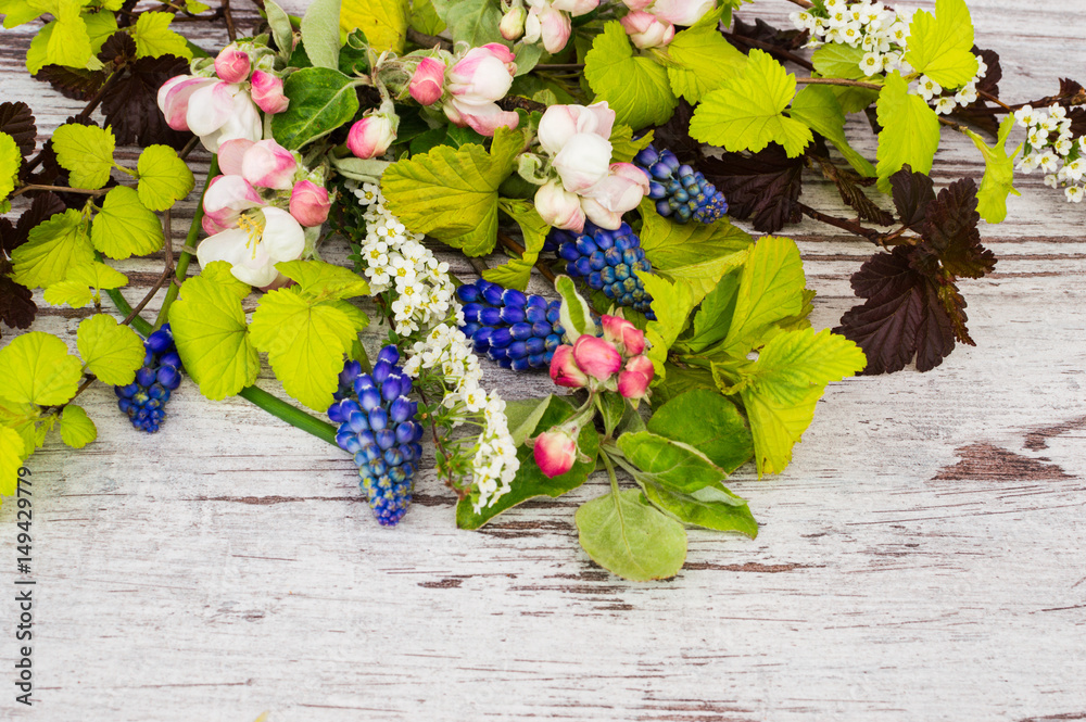 Fresh branches and spring flowers on a white wooden background ...