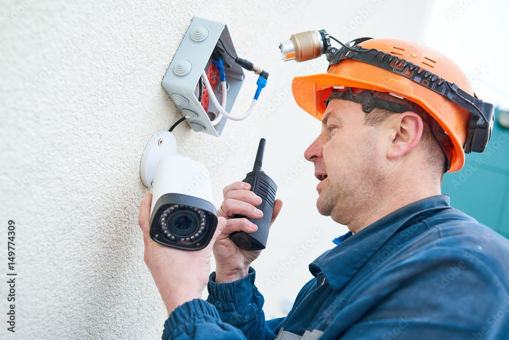 Technician worker installing video surveillance camera on wall Stock ...