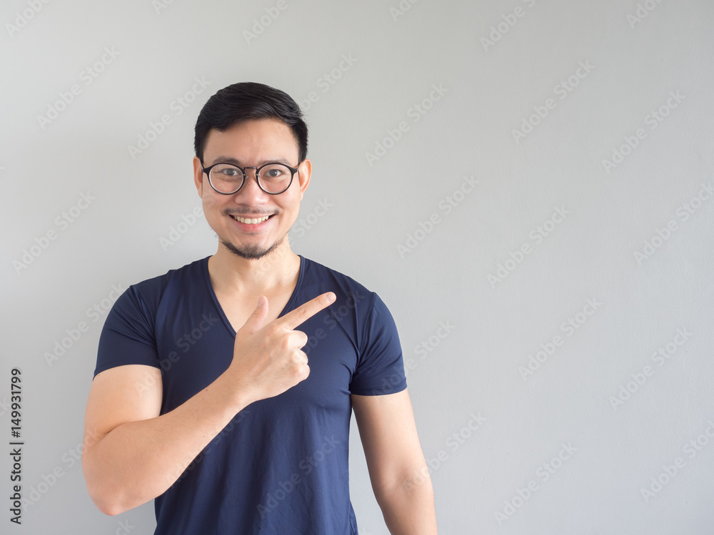 Smileing Asian man point on empty space. Stock Photo | Adobe Stock