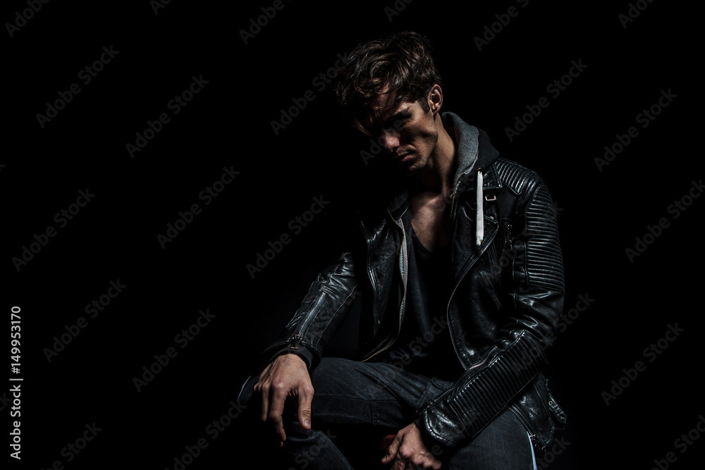 sad dramatic biker in leather jacket sitting Stock Photo | Adobe Stock