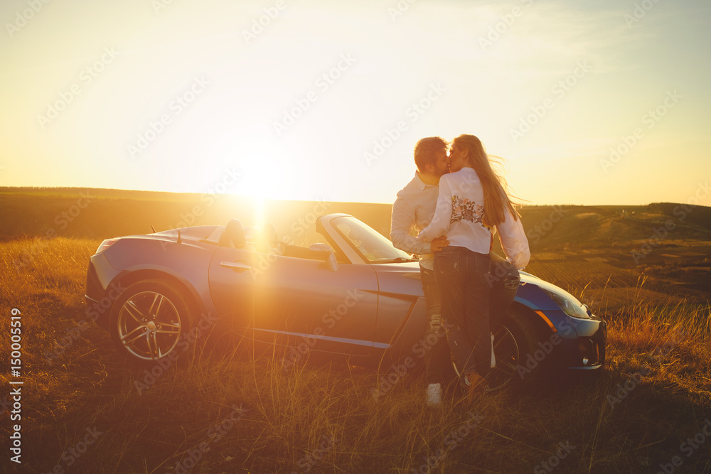 Happiness couple stay near the new sport car hugging and kissing at ...
