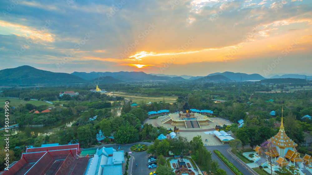 sunset at Huay Mongkol temple.the black Buddha statue name Luang Phor ...