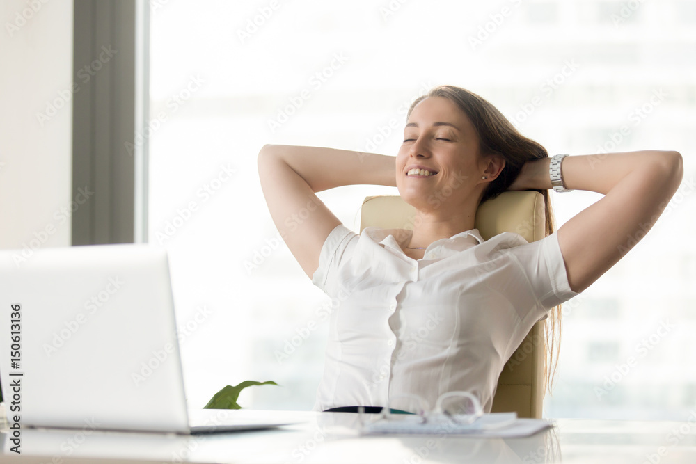 Cheerful businesswoman dreaming at workplace. Smiling girl leaning back ...