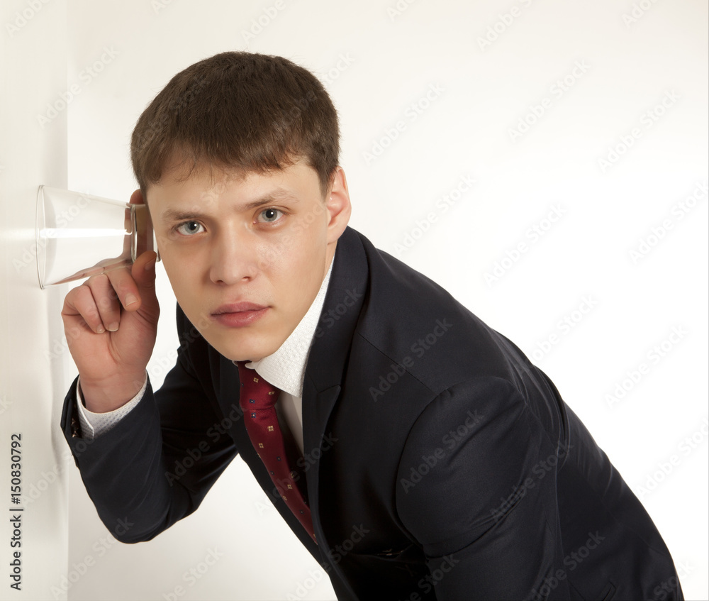 Businessman spying by listening through wall with glass Stock Photo ...