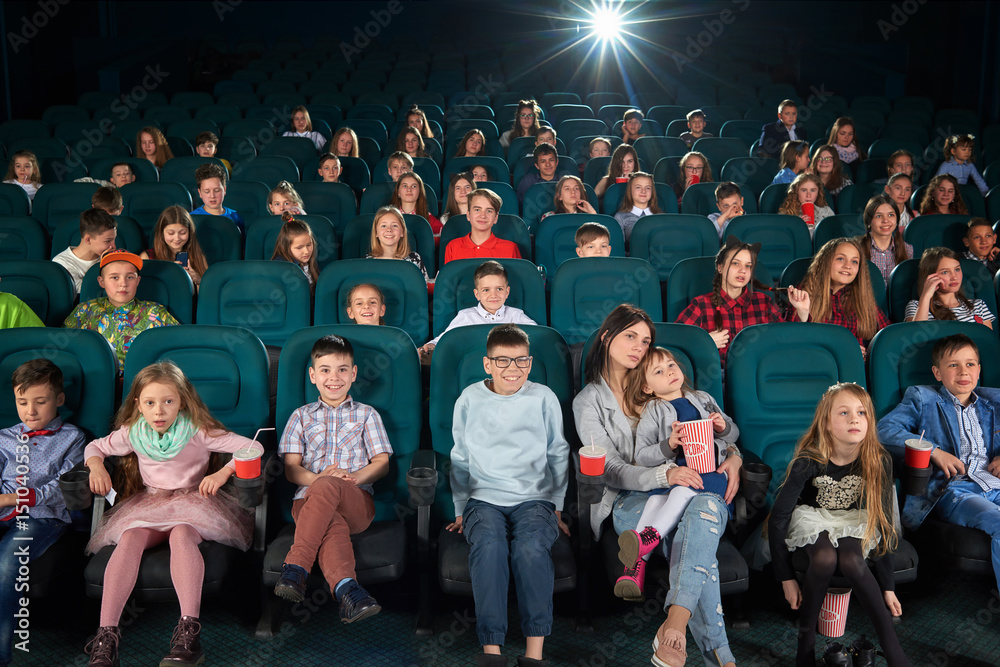 People watching a movie in a dark cinema hall parents kids children ...