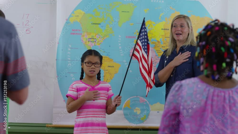 Teacher and student saying pledge of allegiance in school classroom ...