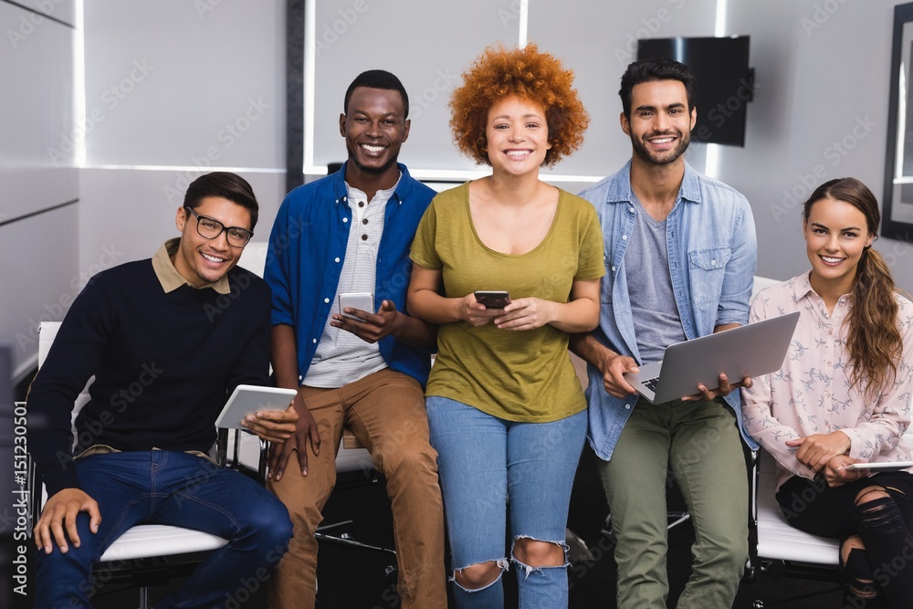 Portrait of happy business colleagues using various technologies Stock ...
