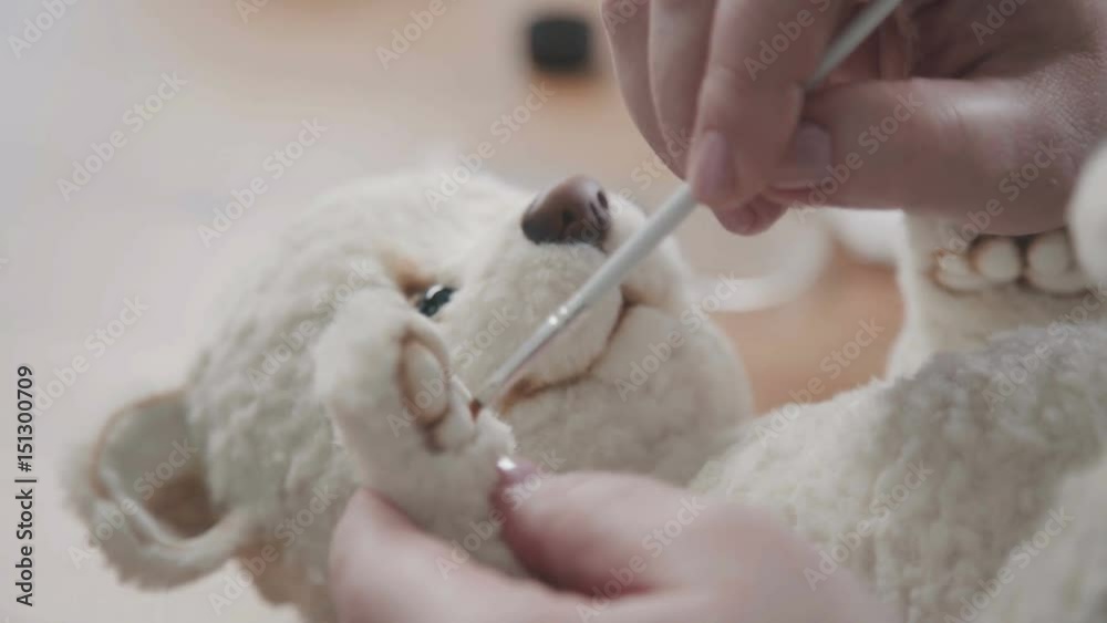 Stockvideon A thin brush in the hands of the artist to create soft toys - drawing details of a ...