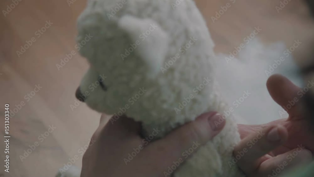 Repair of plush toys: female hands sew a teddy bear. Creating soft ...