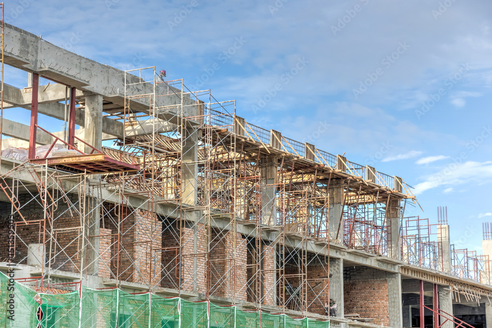 Office and residential building under construction and blue sky. Safety ...