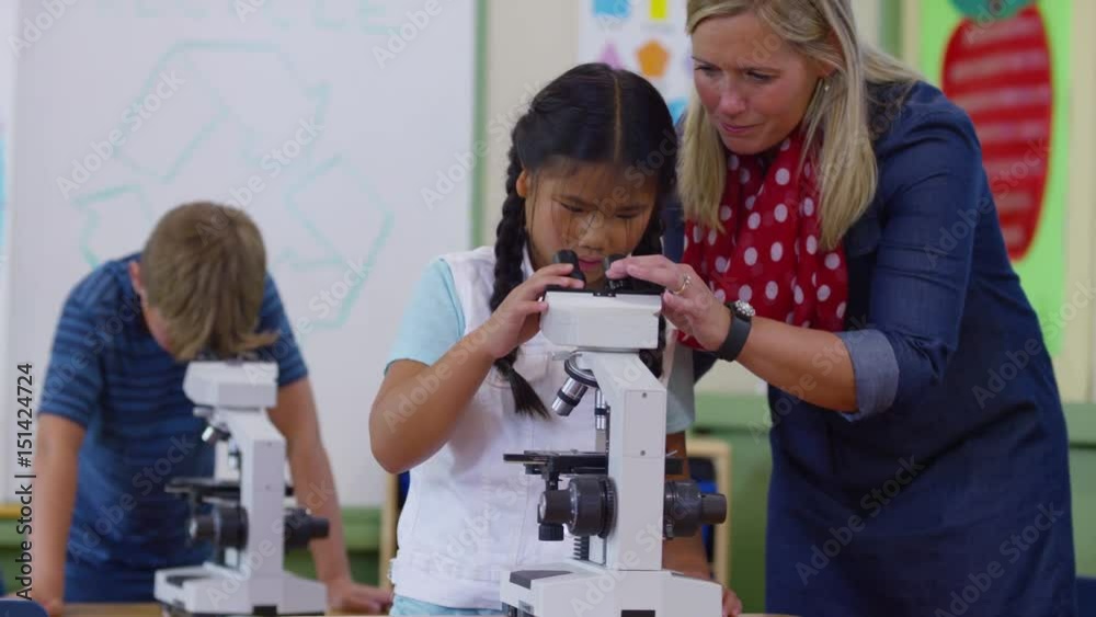 Teacher helping student with microscope in school classroom Stock Video ...