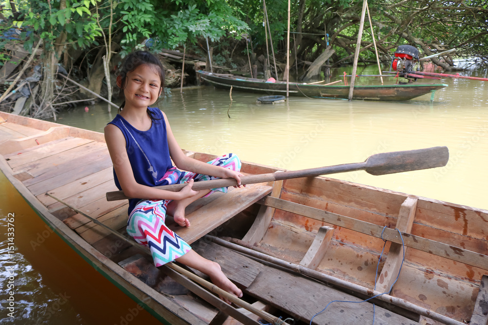 Asian girls are rowing with paddle on a wooden boat in a canal. Stock ...