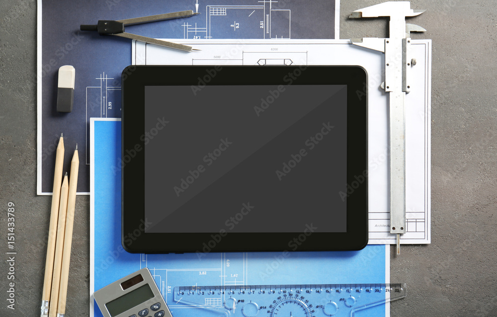 Tablet with blueprints and engineer equipment on table Stock Photo ...