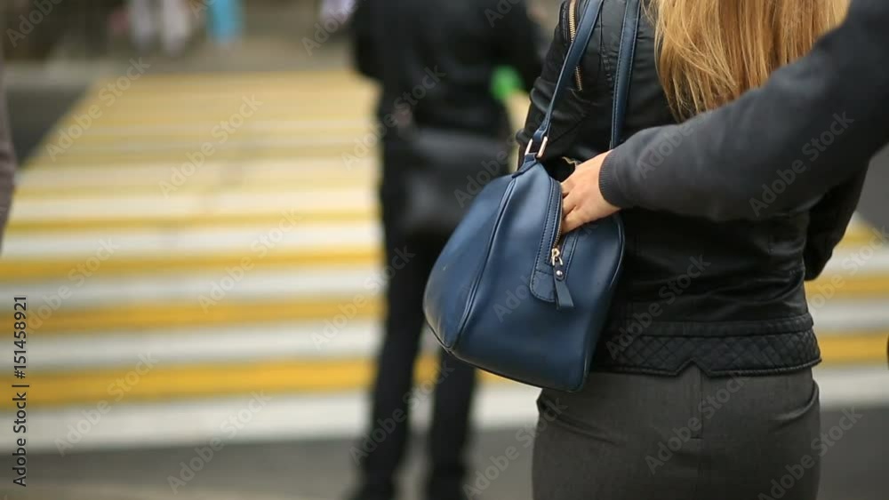 Woman on city street is unaware that her purse has been stolen by ...
