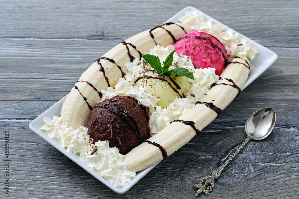 Foto Stock gelato misto con banana e panna montata su sfondo grigio ...