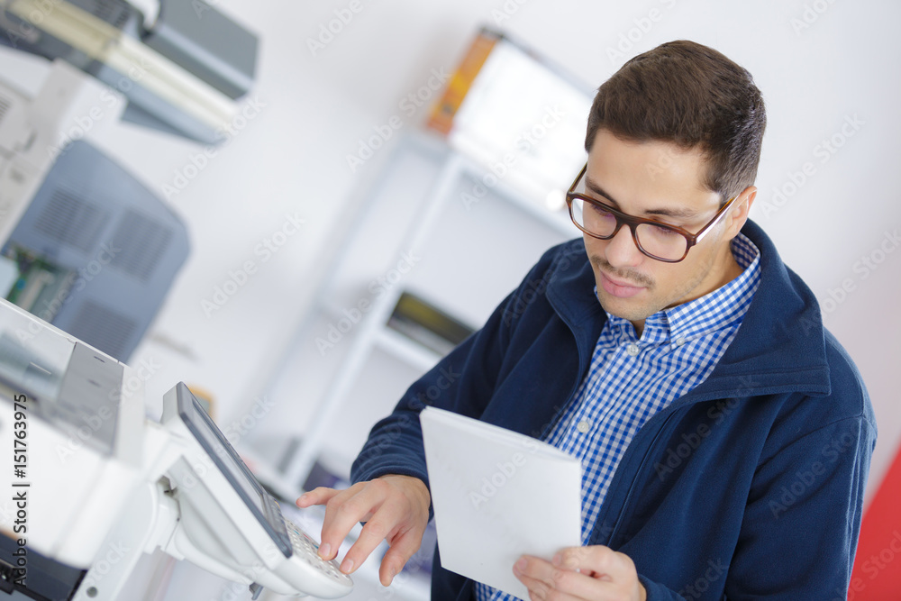 Man programming photcopier Stock Photo | Adobe Stock