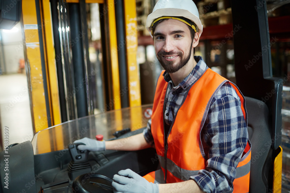 Warehouse loader in forklift truck looking at camera Stock Photo ...