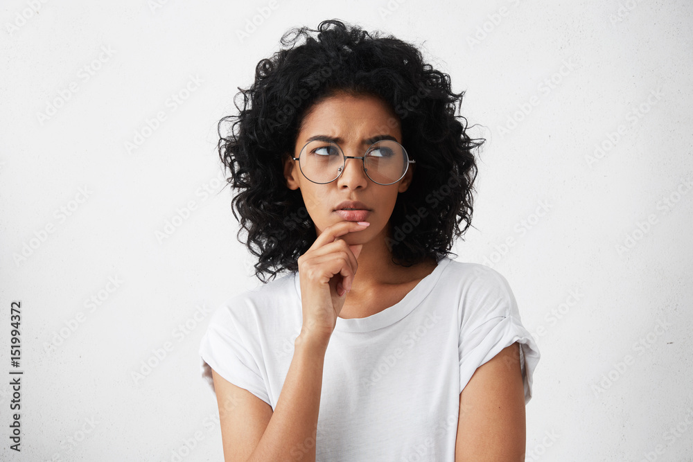 Hmm. Suspicious thoughtful young mixed race female with black curly ...