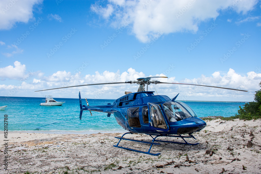 Blue helicopter on the beach on tree and beautiful ocean and clouds at ...