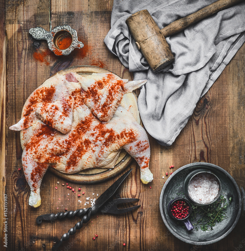 Raw Chicken Tabaka flattened out with old meat hammer, spices and ...