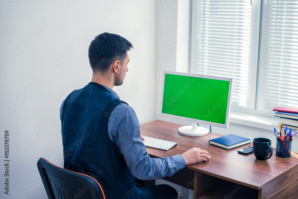 Young man office worker sitting at computer with Chromakey and looking ...