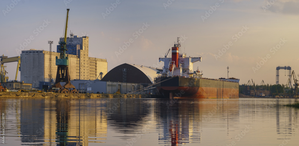 Bulk carrier moored at the quay, and busy with cargo operations ...