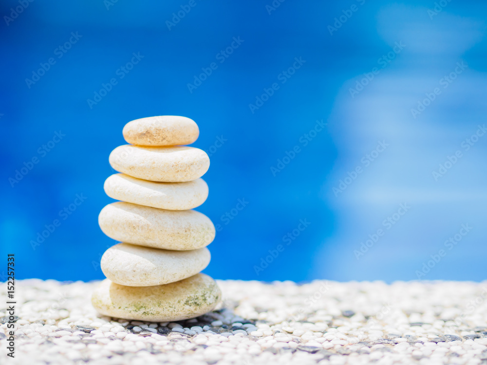Balance Stones stacked to pyramid in the soft blue water background to ...