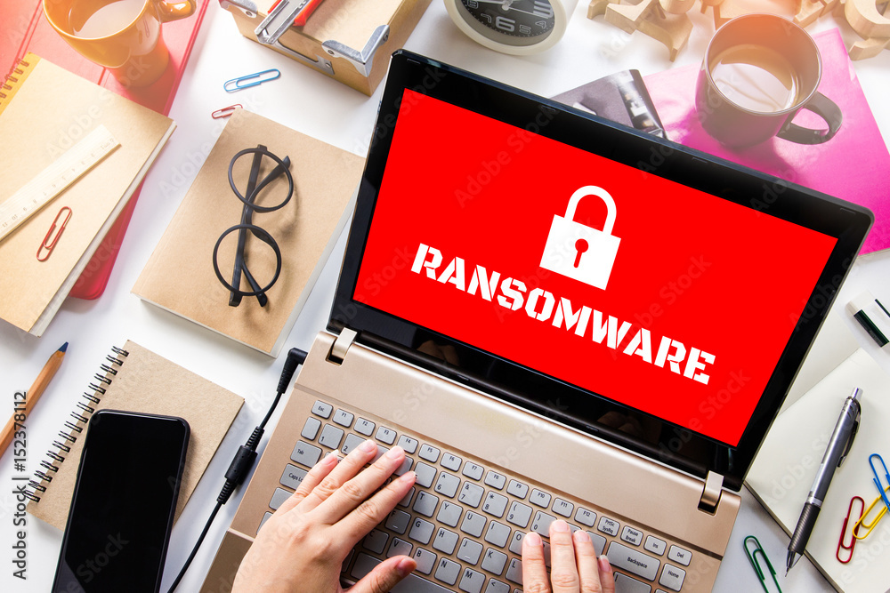 Laptop on desk Showing Red Screen with Padlock icon and Ransomware ...