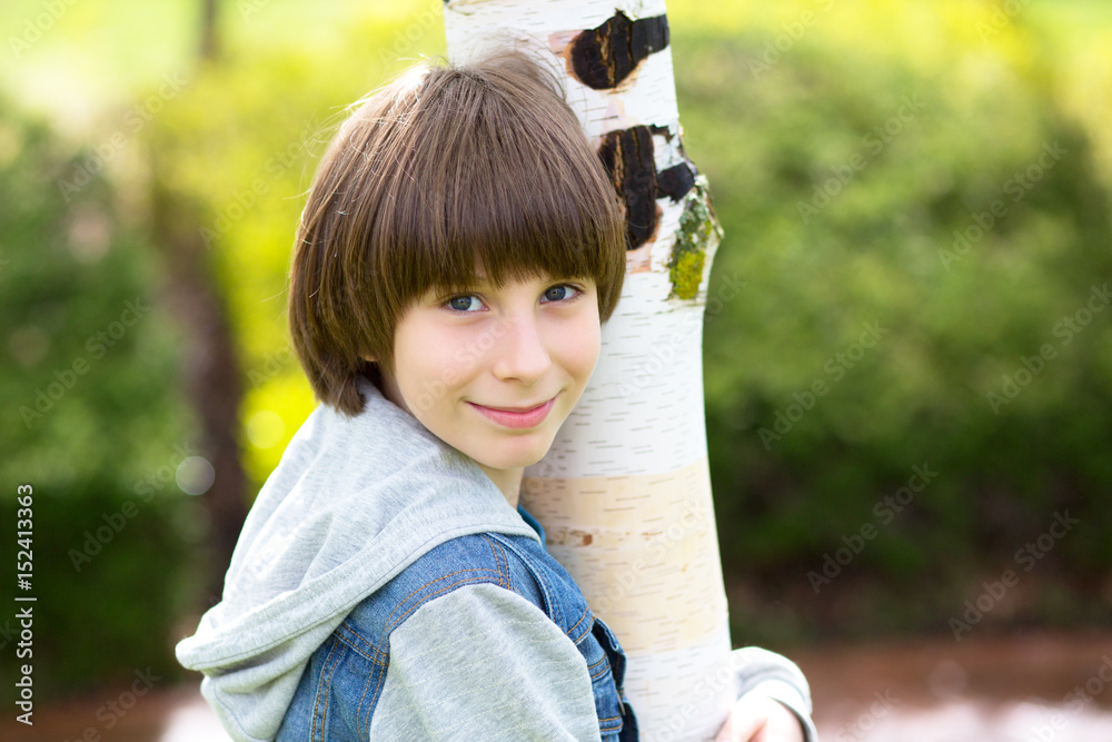 Outdoor handsome boy's portrait. Teen boy neer the birch in spring park ...