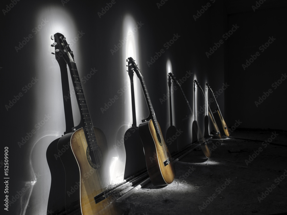 Acoustic guitar leaning on rusty wall in dark room with lights. Surreal ...