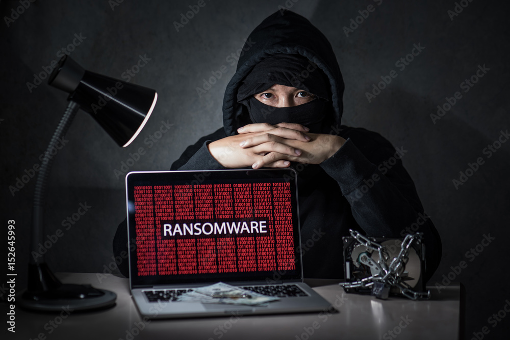 Hacker with laptop computer screen showing ransomware attacking, alert ...