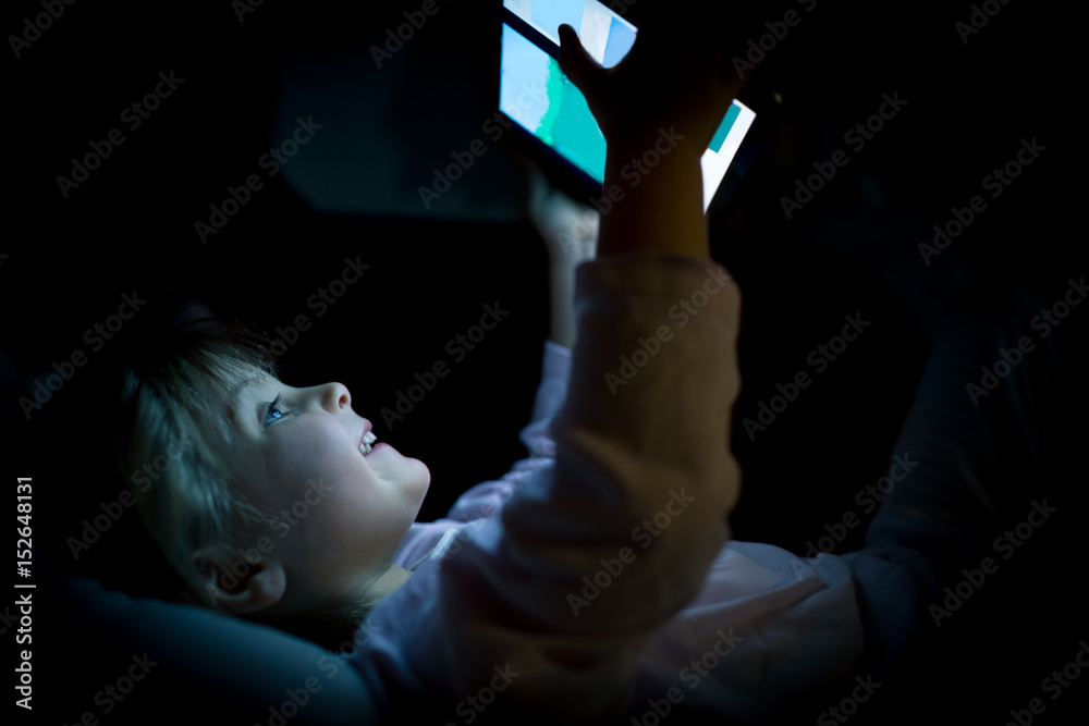 Fotografia do Stock: little child girl using tablet technology in bed ...