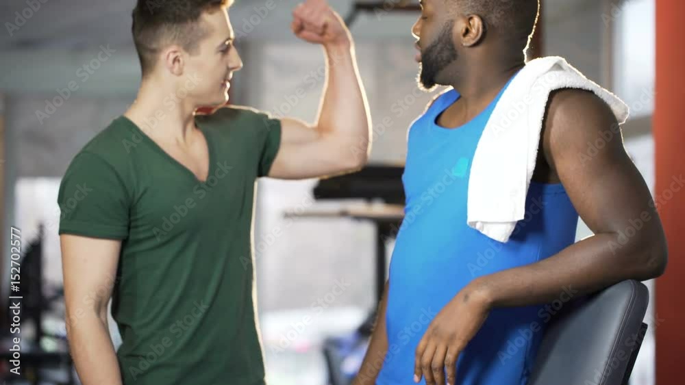 Competitive athletic men comparing and boasting biceps muscles, friends ...