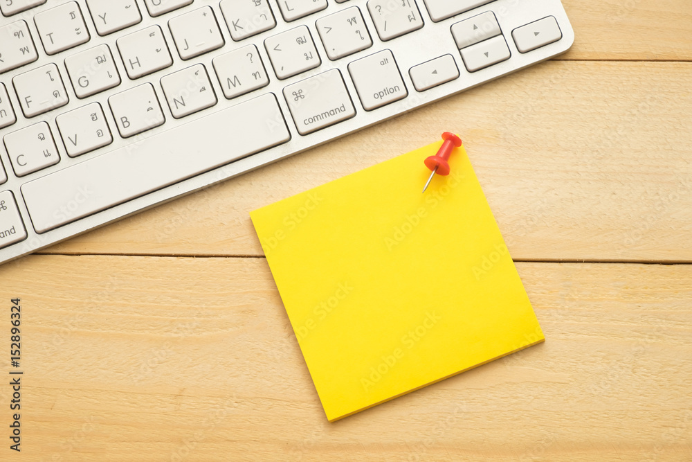 top view. pin put on top yellow post-it note. both putting beside ...