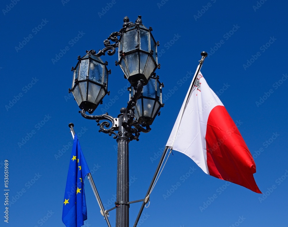 Wrought iron streetlight with the Maltese flag and European Union flag ...